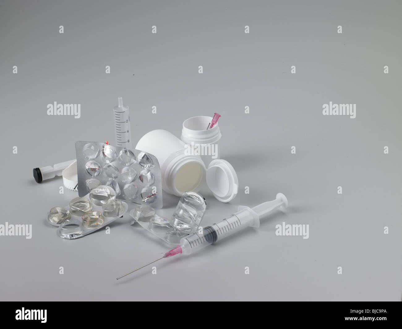 Waste pharmaceutical packaging and syringe with white plastic pill ...