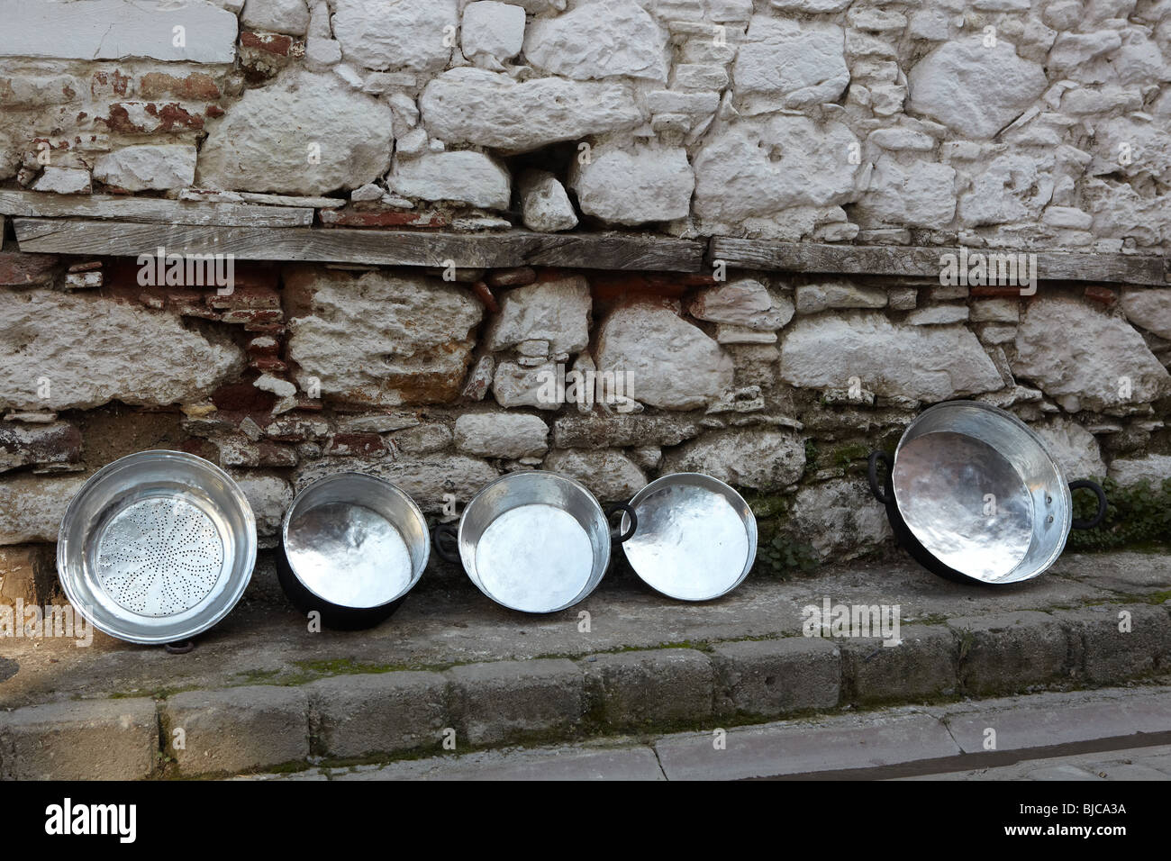 handmade metal pots outside a workmans forge next to the street ...