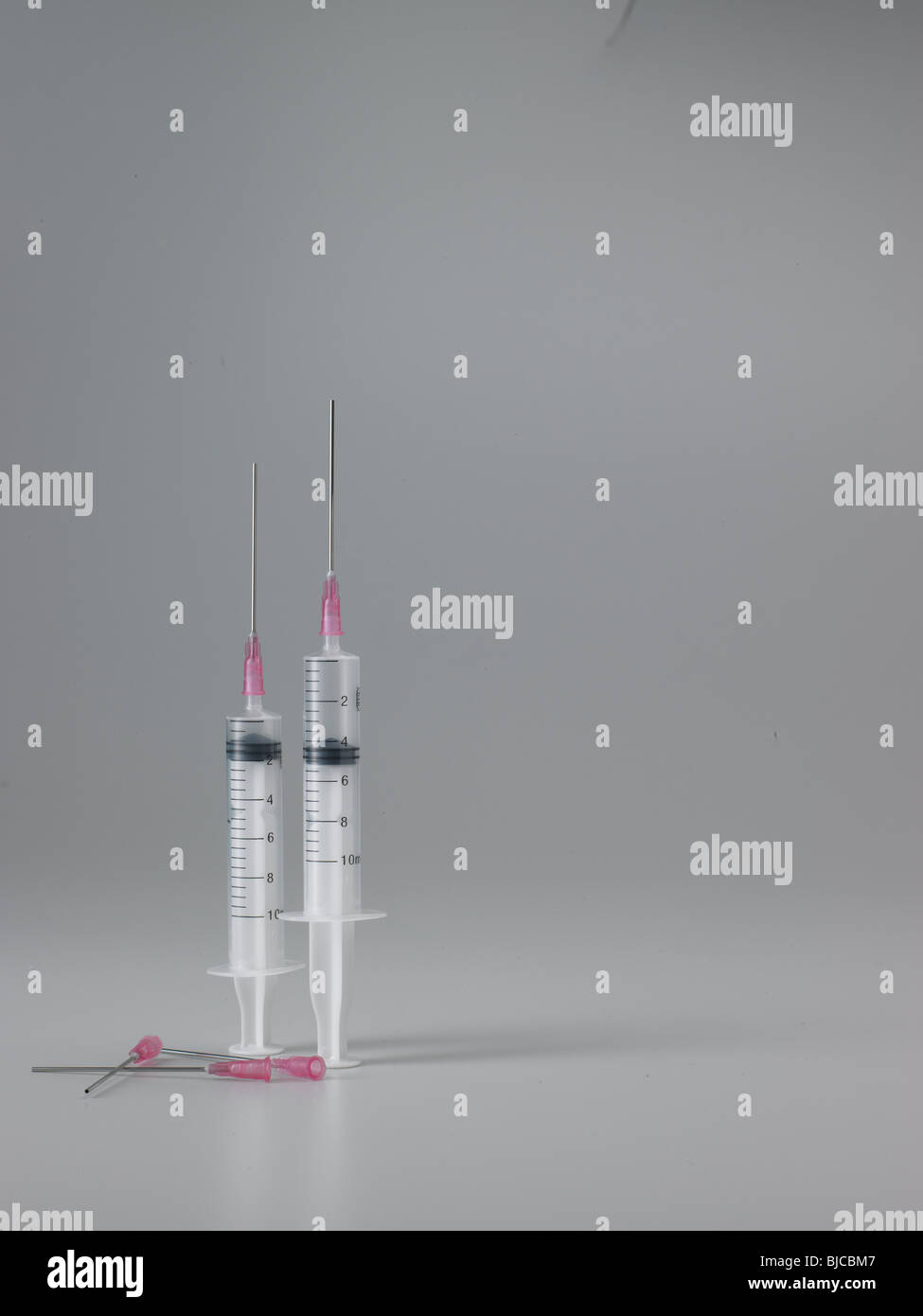 Syringes and needles standing upright Stock Photo - Alamy