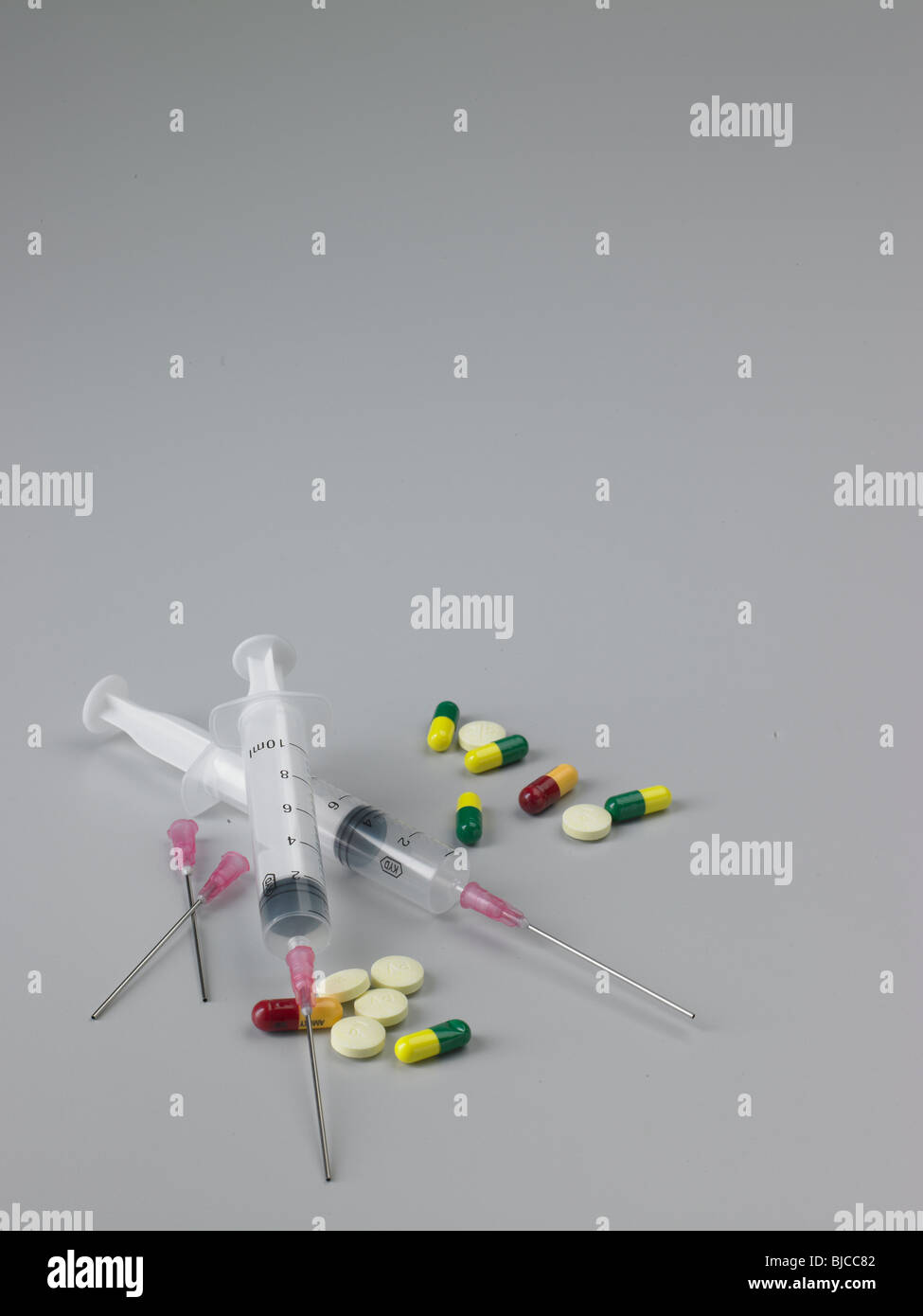 Syringe and needles with capsules and tablets in portrait format Stock ...
