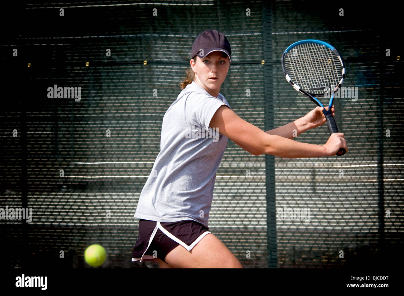 Female college tennis player hitting slice background Stock Photo - Alamy