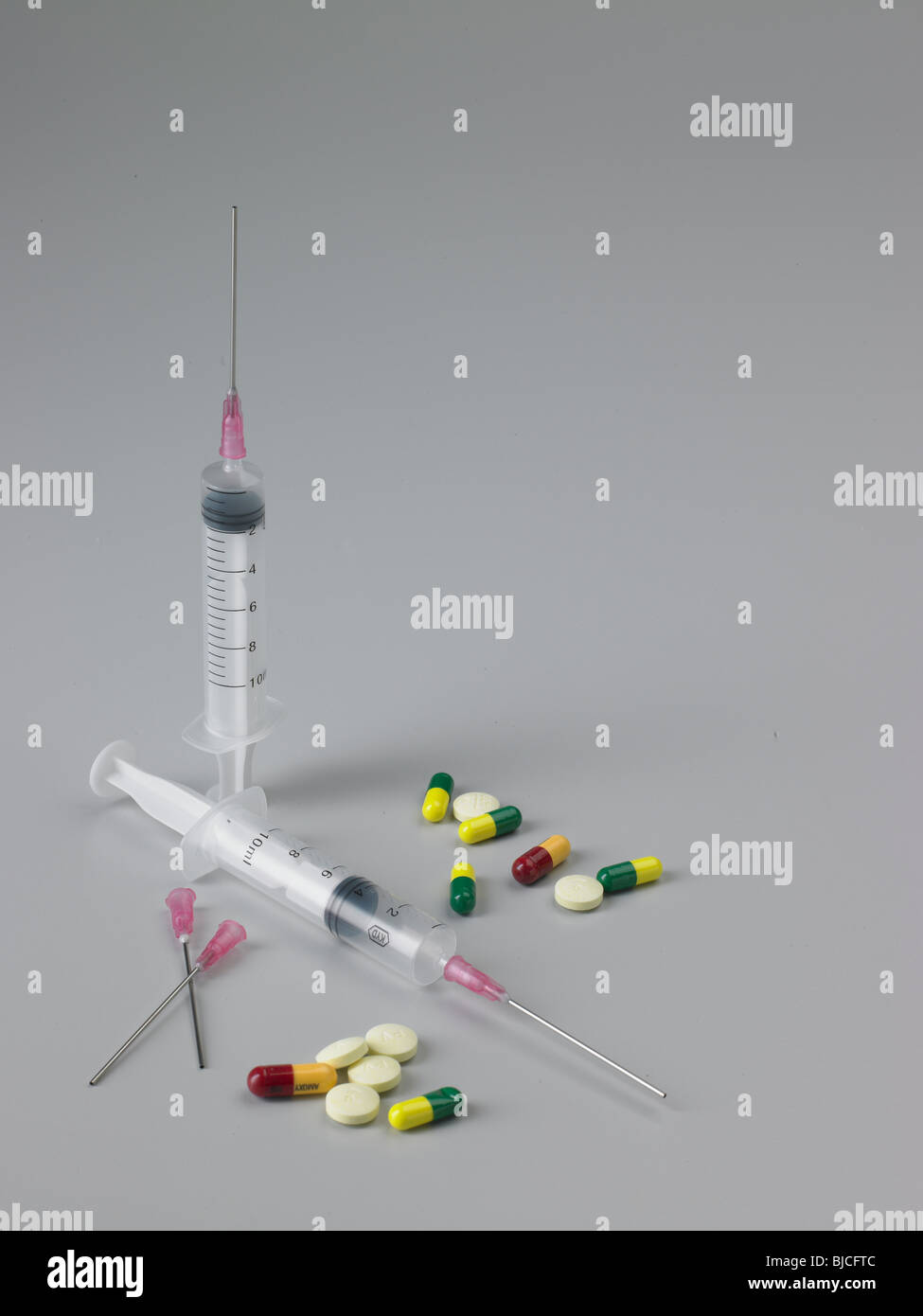 Group of Syringes and needles with capsules and tablets in text ...