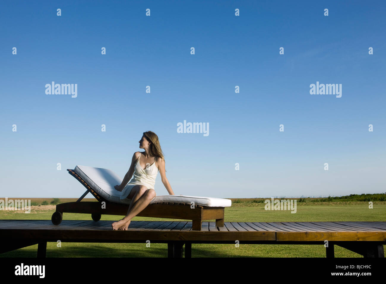 Woman relaxing on lounge chair outdoors Stock Photo - Alamy