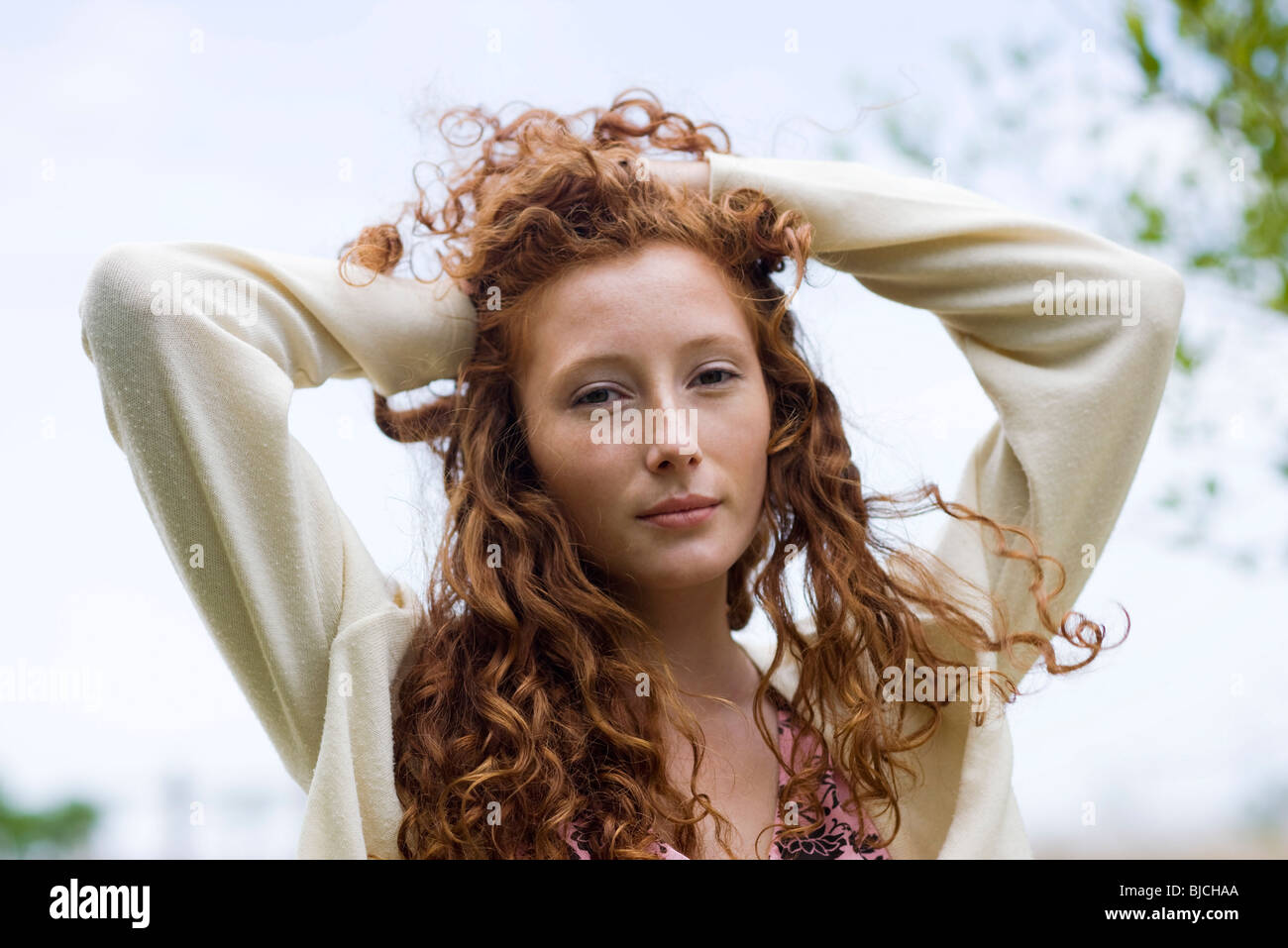 Young woman with hands on top of head, portrait Stock Photo - Alamy