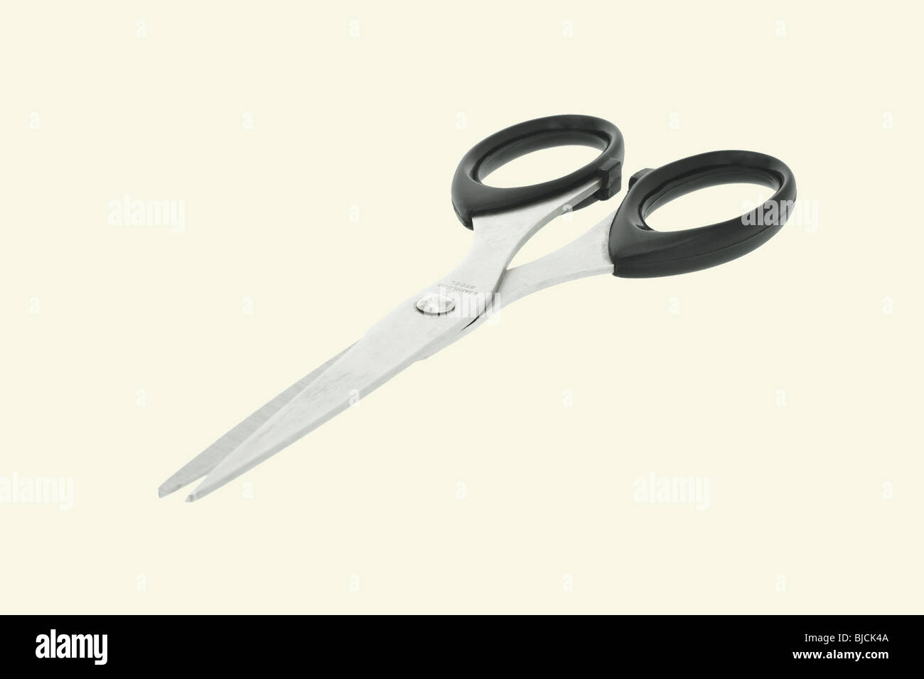 A pair of scissors with black handles isolated on off white background ...