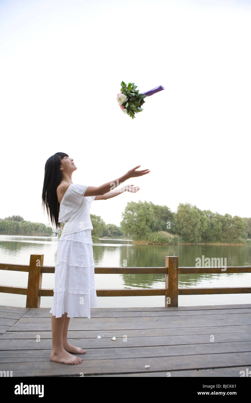 Young woman throwing bouquet outdoors Stock Photo - Alamy