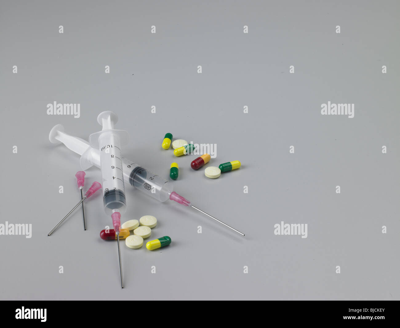 Syringe and needles with capsules and tablets Stock Photo - Alamy