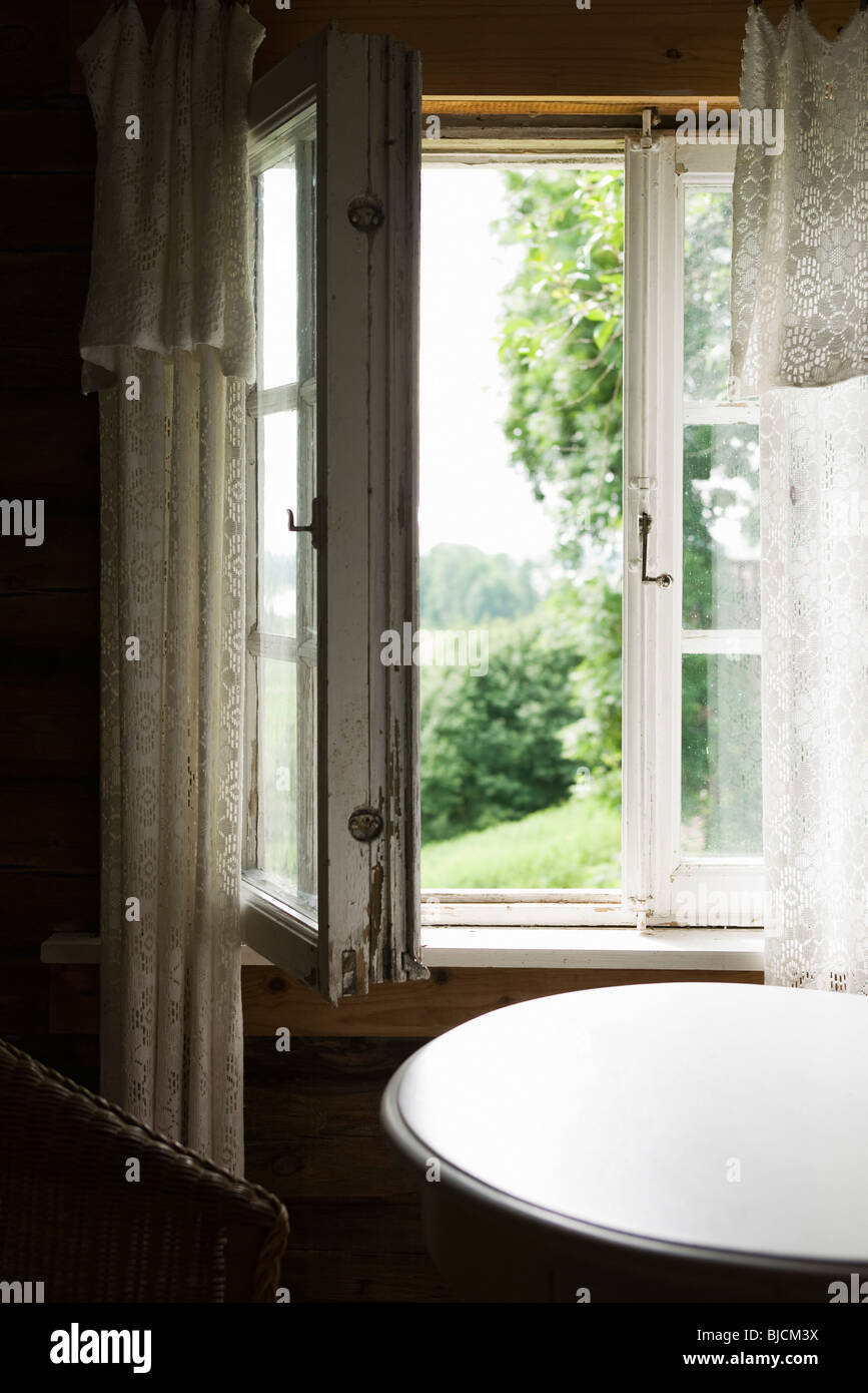 Table by open window Stock Photo - Alamy