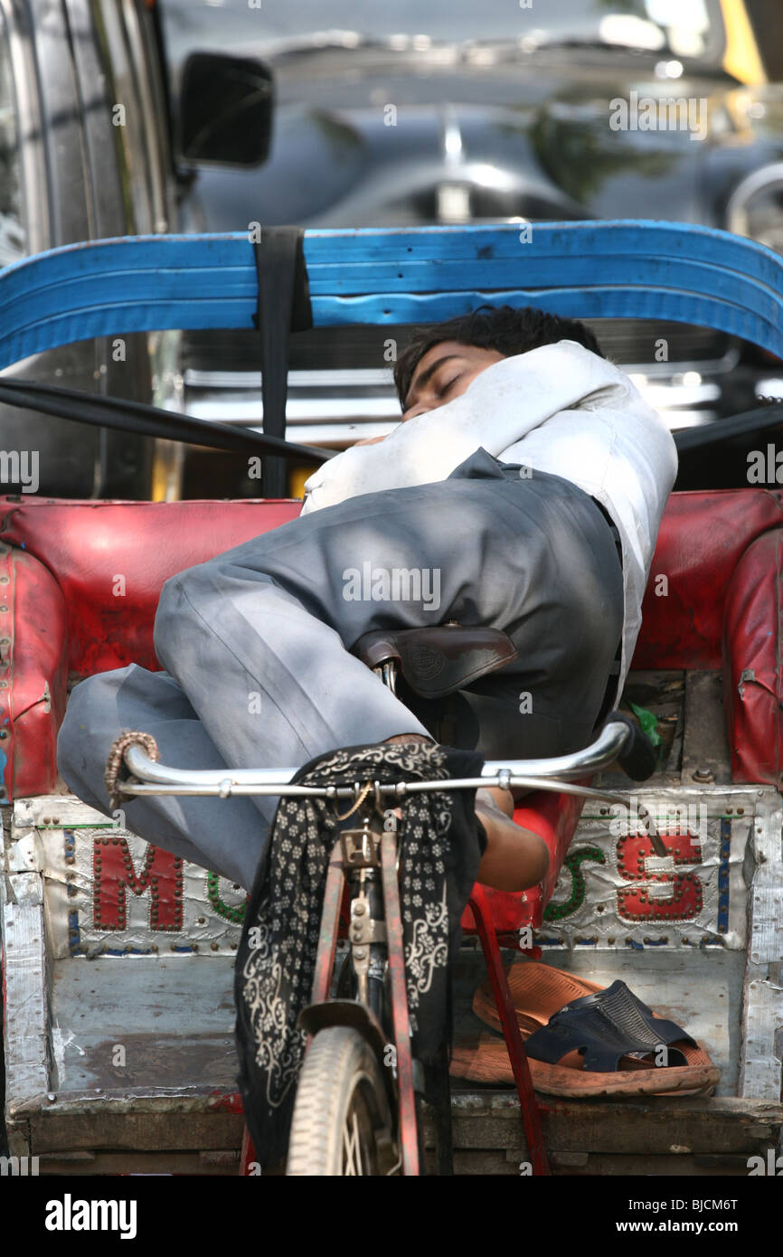 Street scenes in New Delhi- India, man sleeping on his bike Stock Photo ...