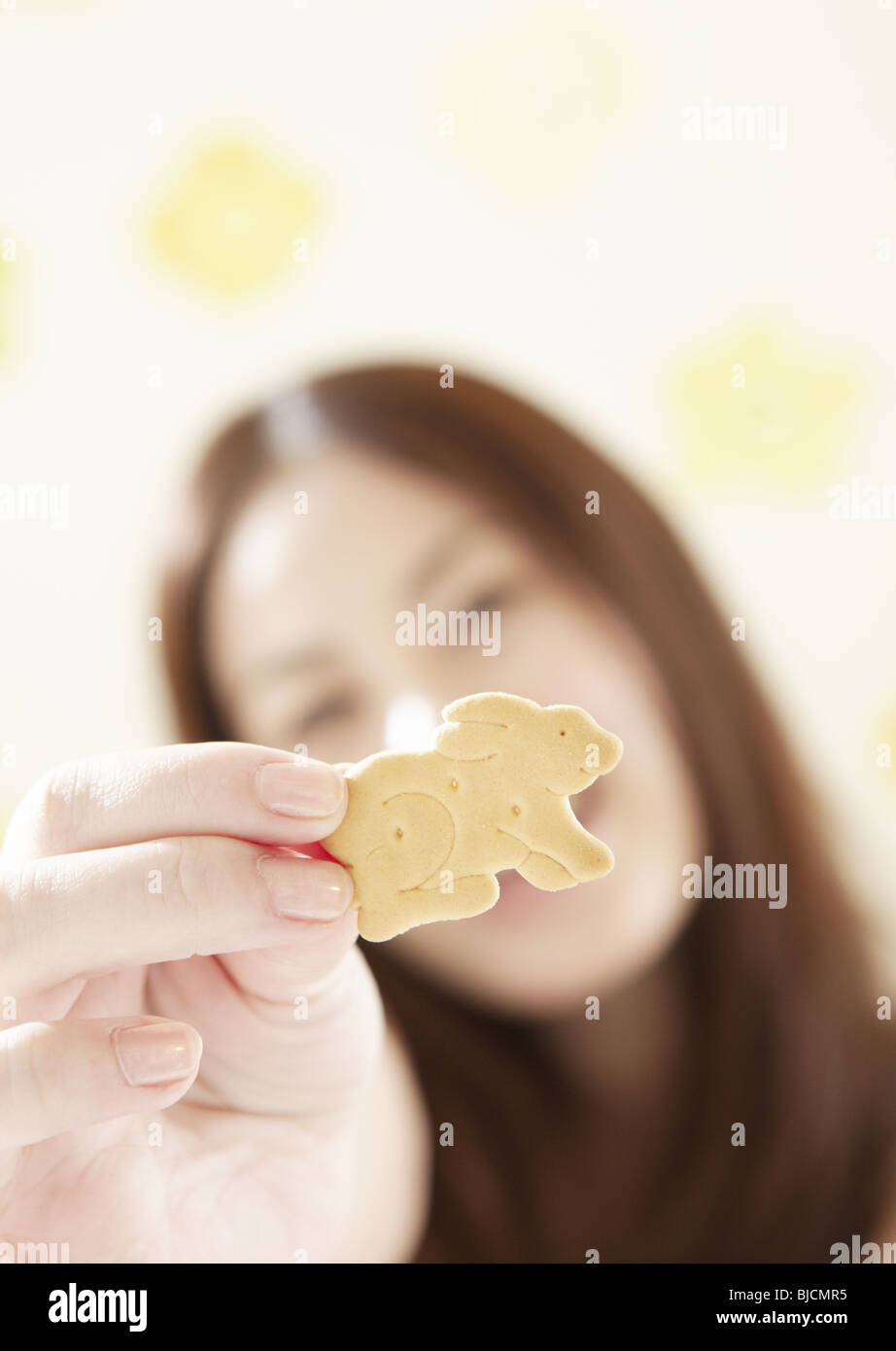 A woman showing a biscuit Stock Photo - Alamy