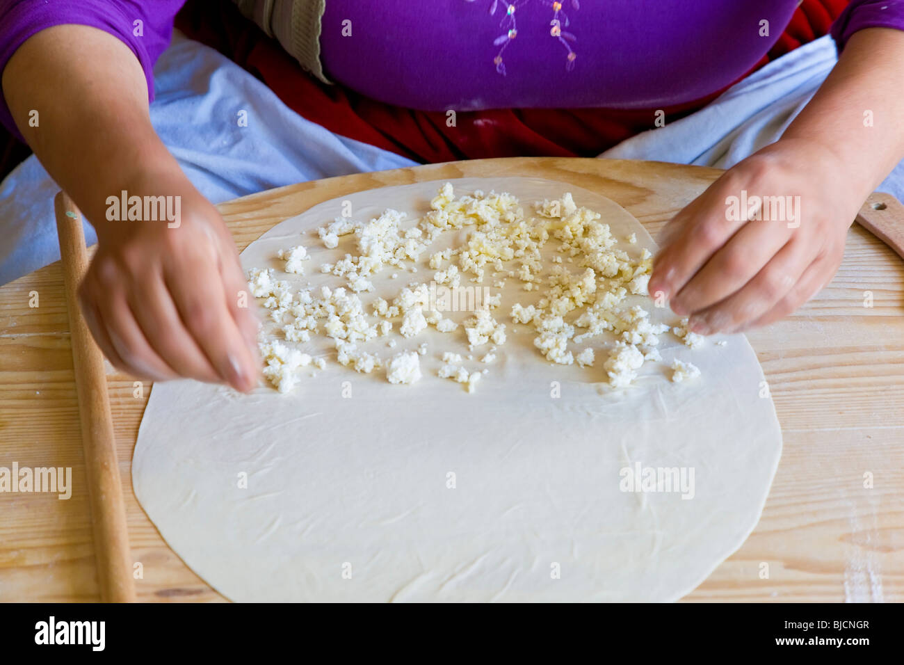 Woman making Gozleme, thin bread filled with potato, spinach, cheese or ...