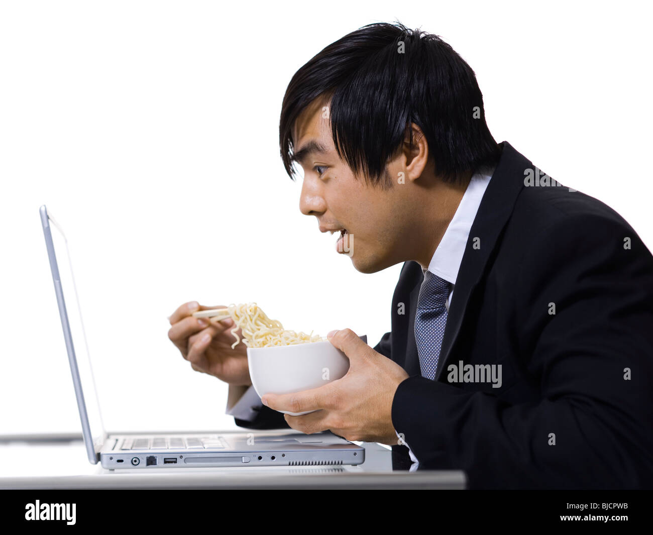 Man eating with laptop Stock Photo - Alamy