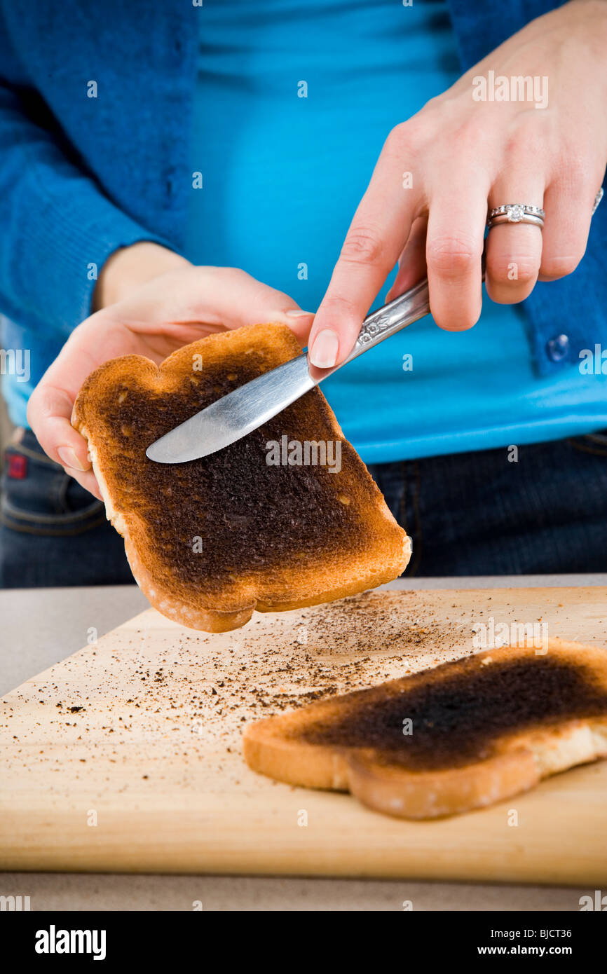 woman scraping toast Stock Photo - Alamy