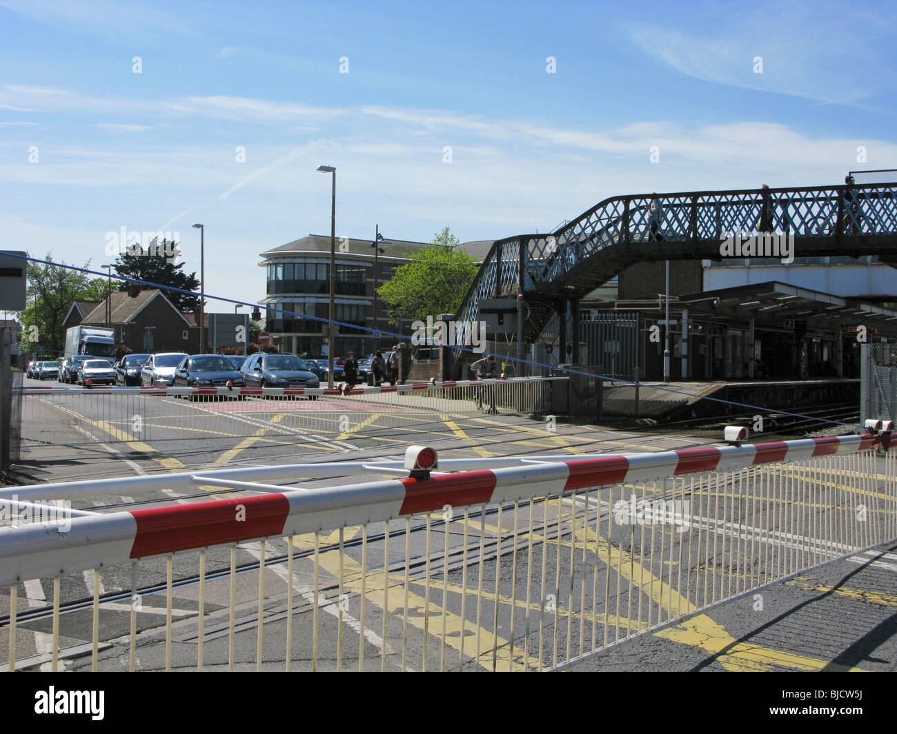 traffic building up at a railway level crossing with the barriers down ...