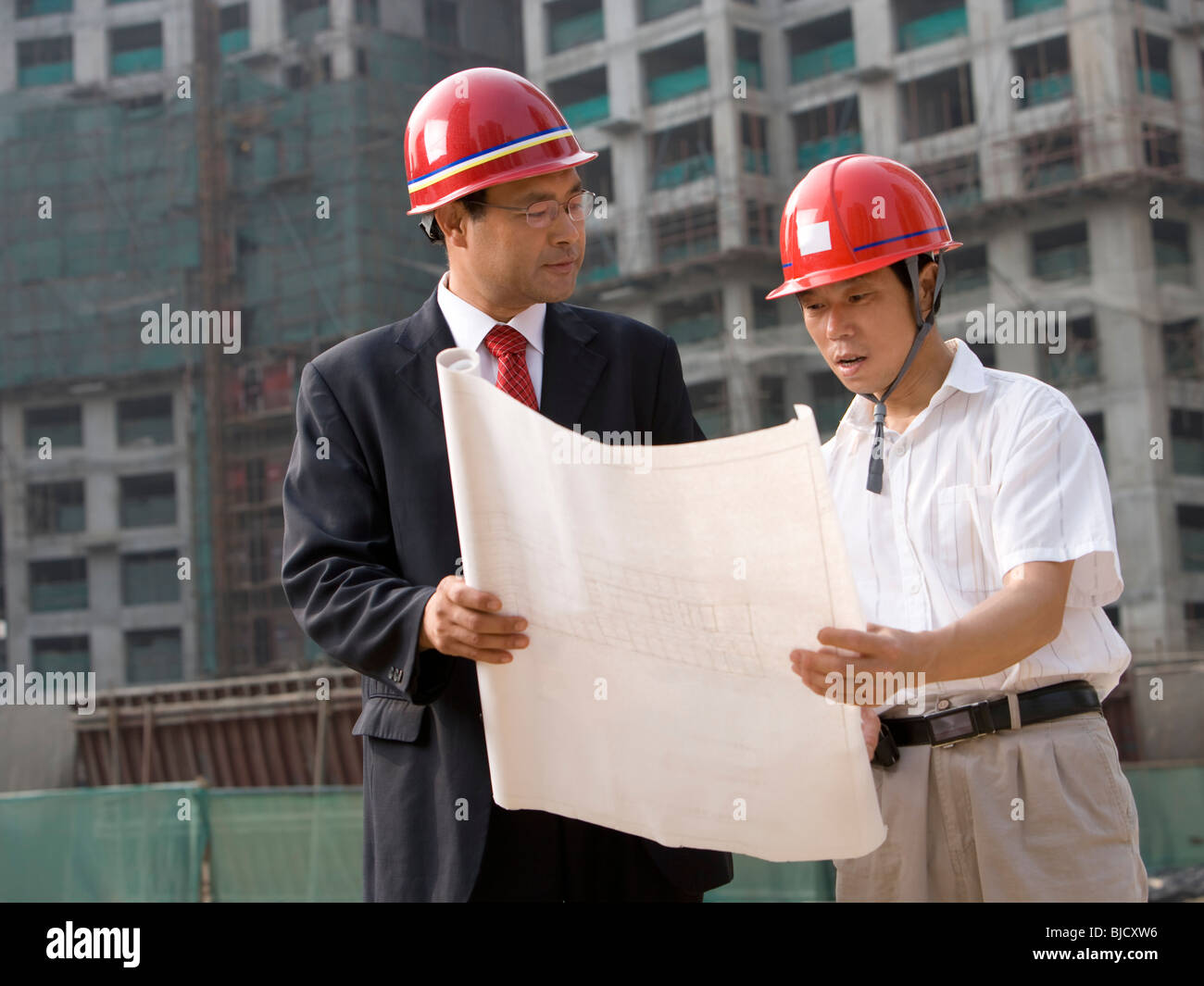 Architect on the job site with a worker Stock Photo - Alamy