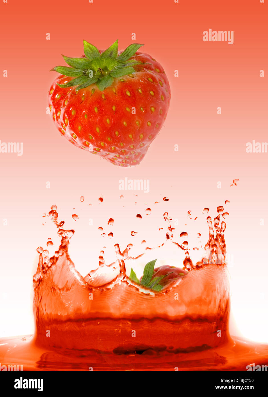Strawberry falling in juice. Isolation Stock Photo - Alamy