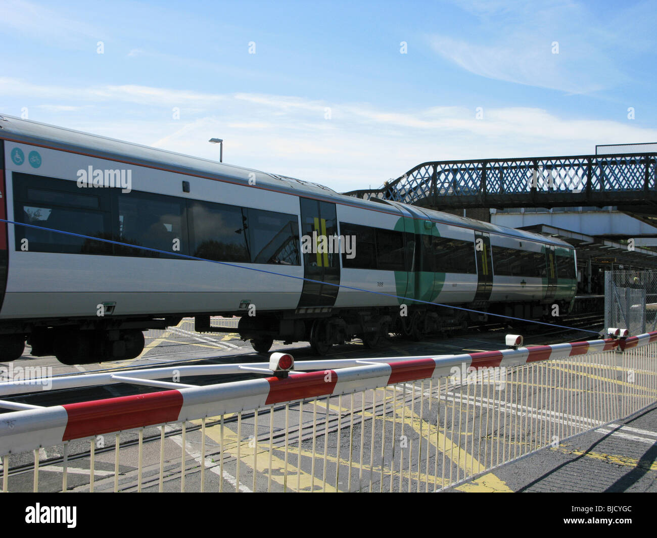 railway level crossing barriers down with a train speeding through into ...