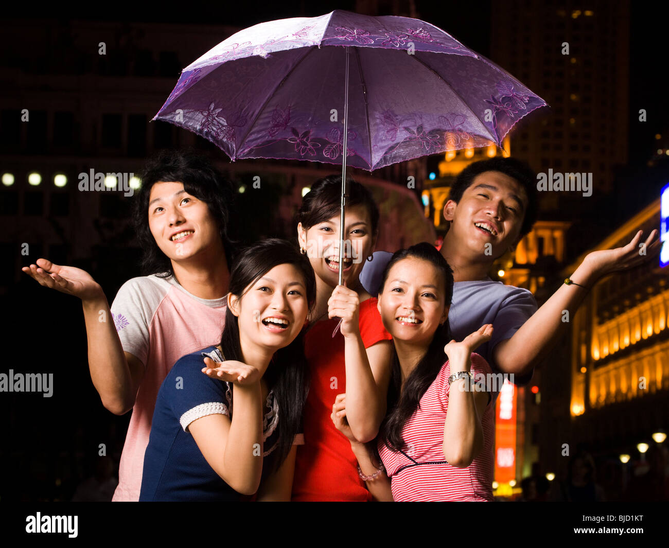 Five young people under an umbrella Stock Photo - Alamy