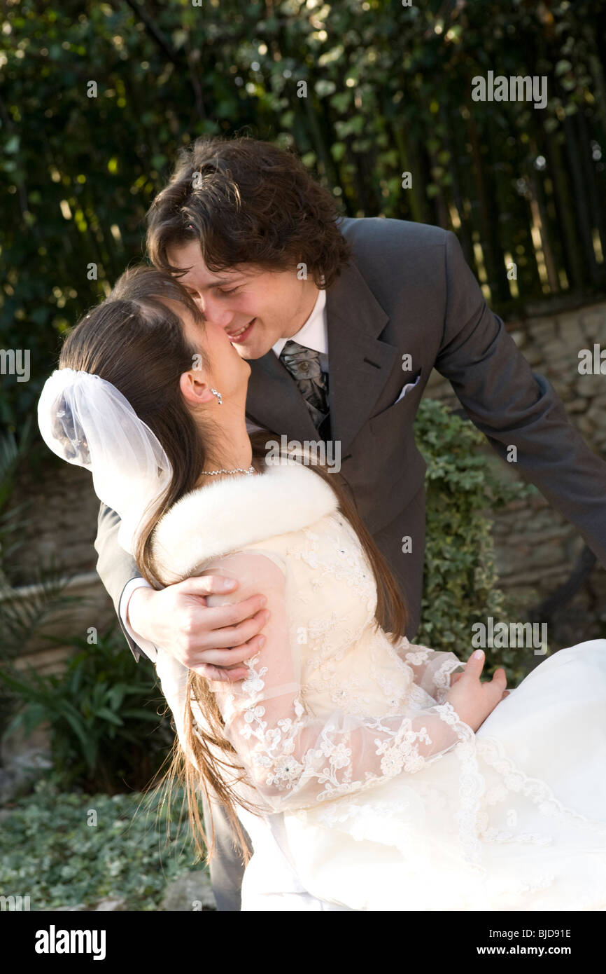 Bride and bridegroom hugging, kissing, and smiling Stock Photo - Alamy
