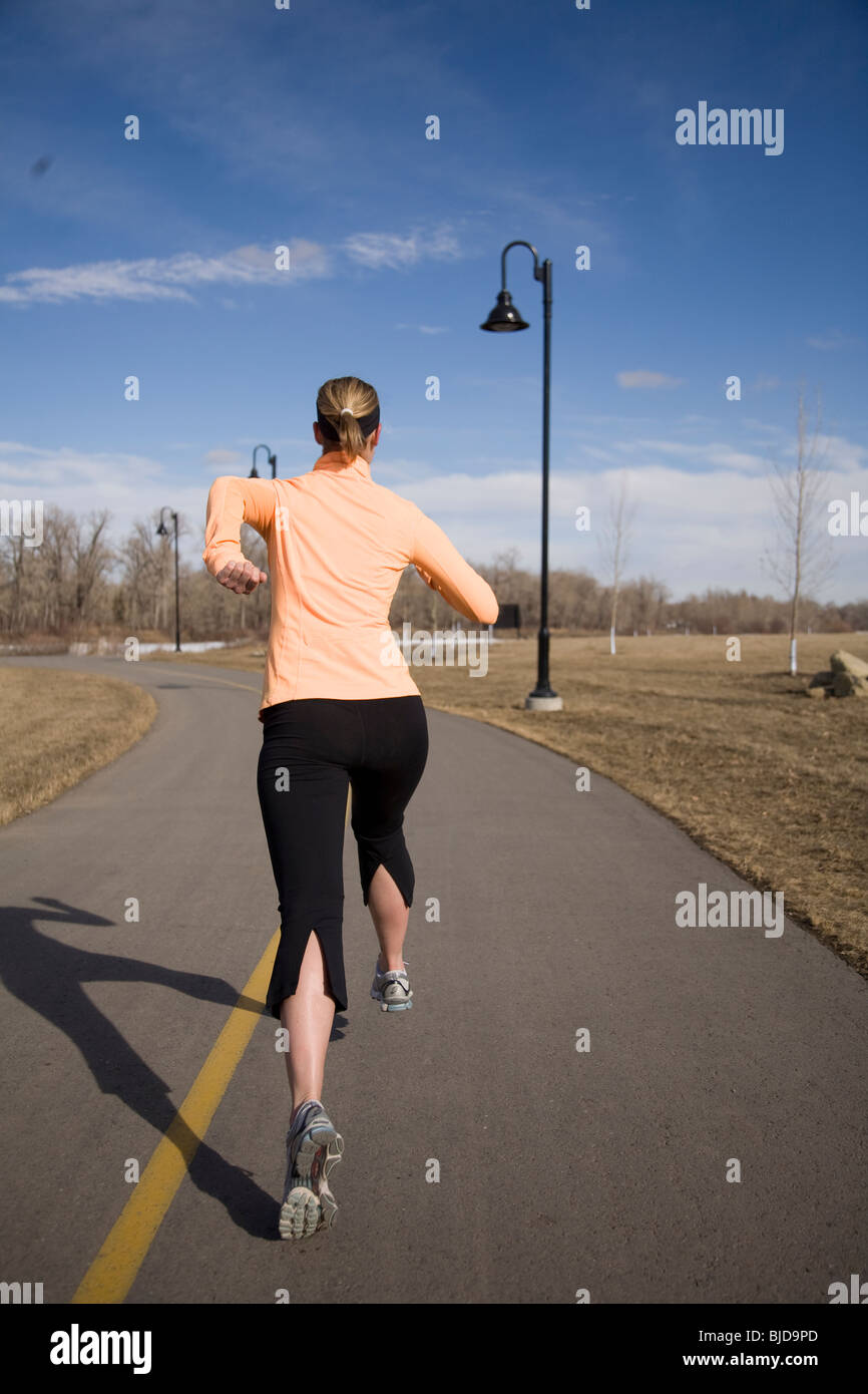 female is running on a pathway away from the camera Stock Photo - Alamy