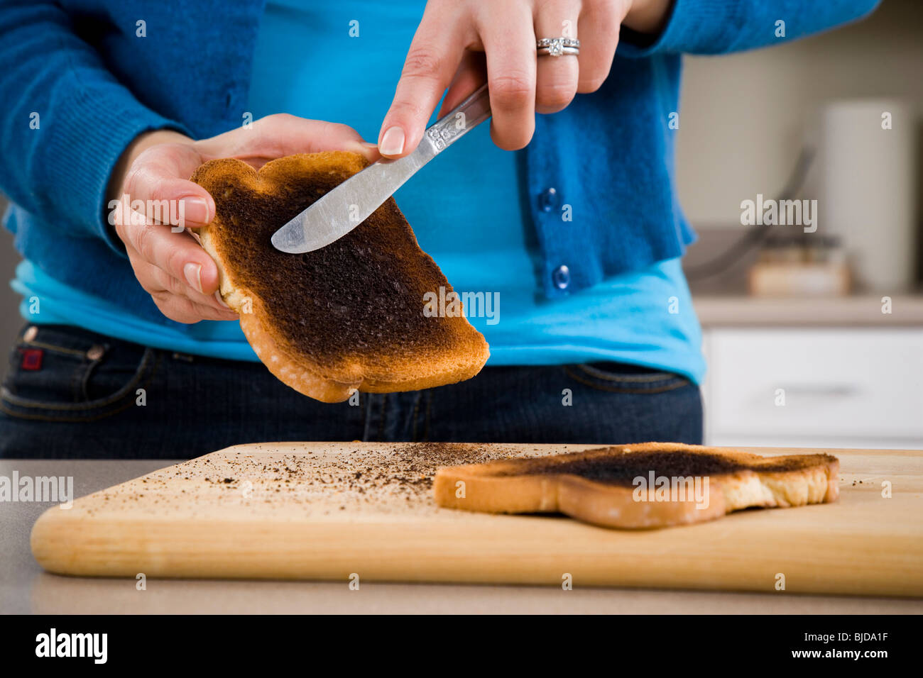 woman scraping toast Stock Photo - Alamy