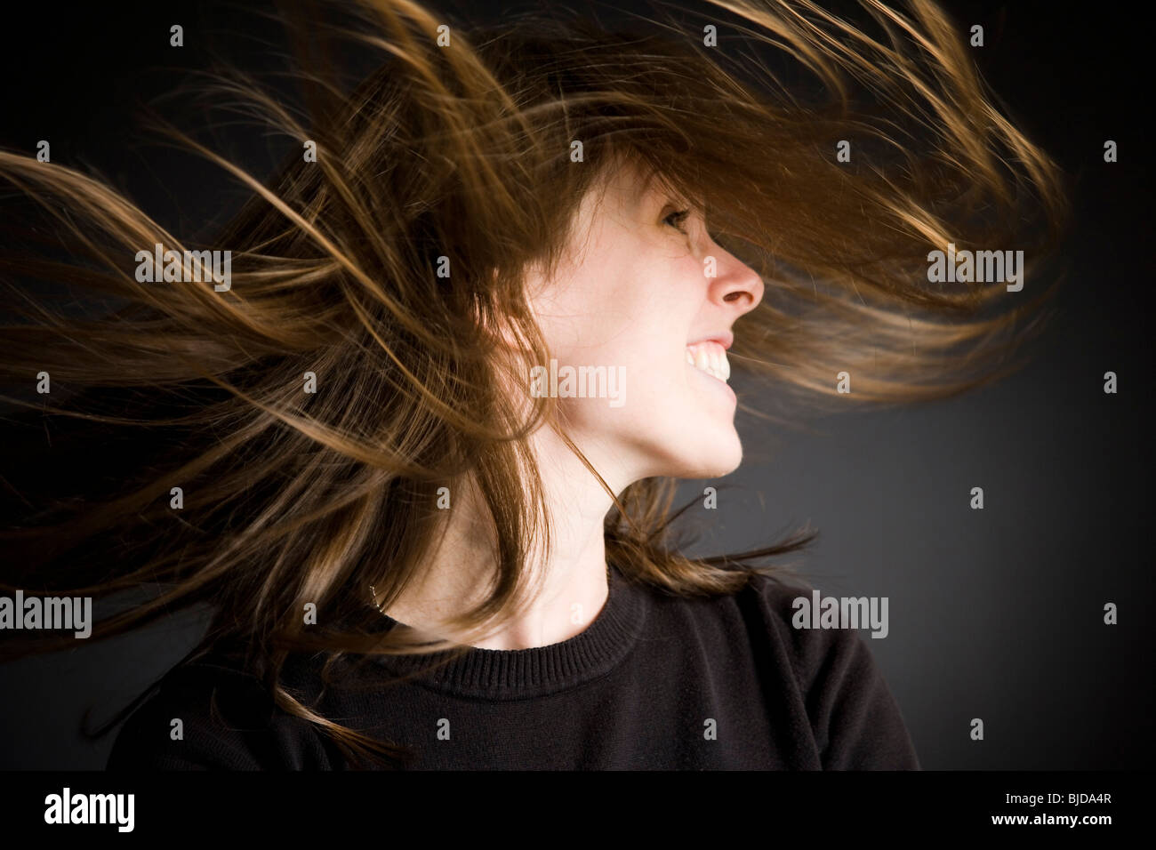Woman flipping hair Stock Photo - Alamy