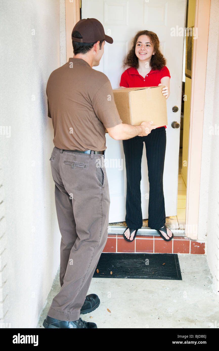 Girl receiving a package from a delivery man Stock Photo - Alamy