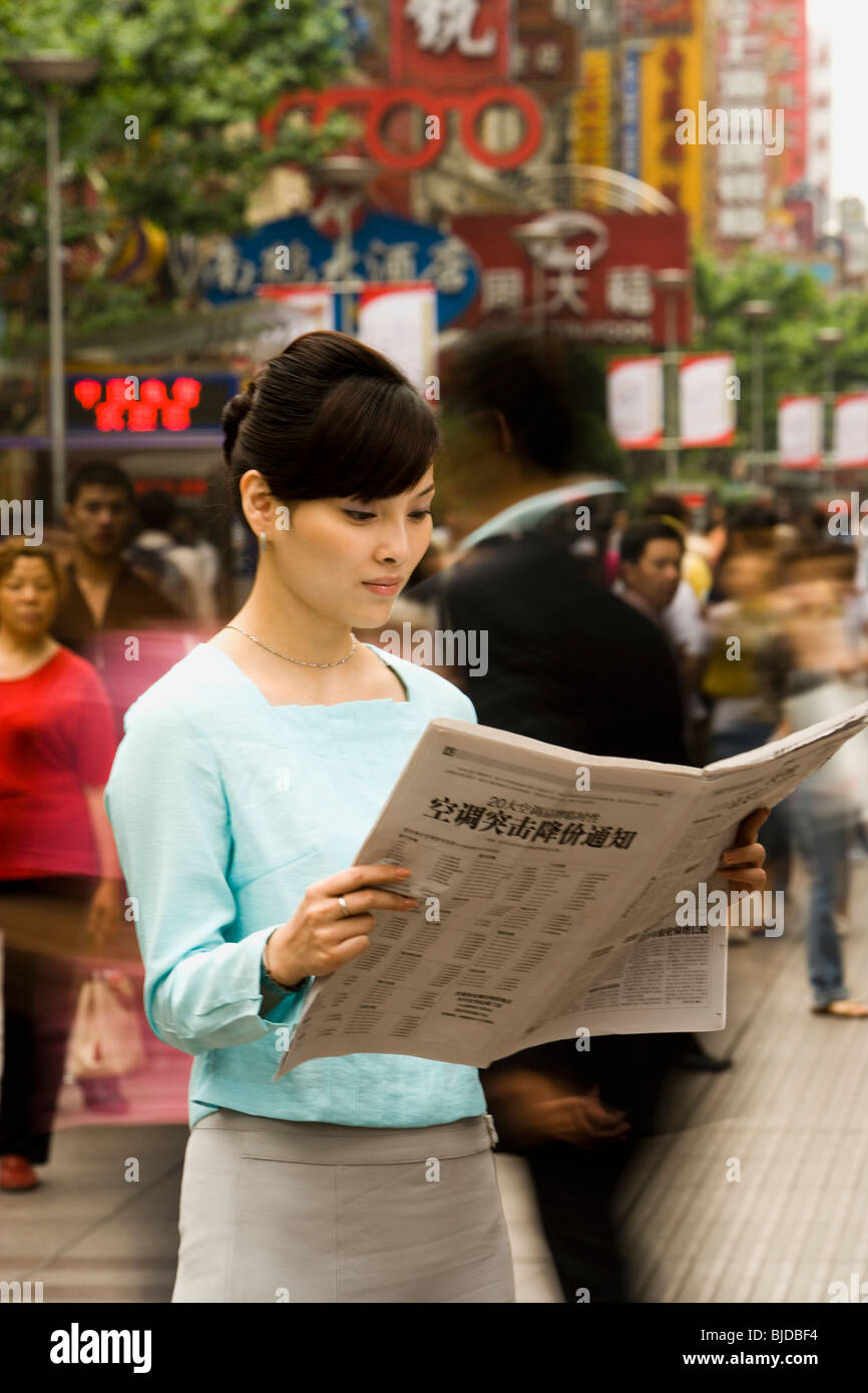Woman reading a newspaper Stock Photo - Alamy