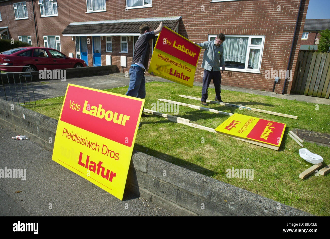 Labour Party workers erect bilingual Welsh English VOTE LABOUR signs ...