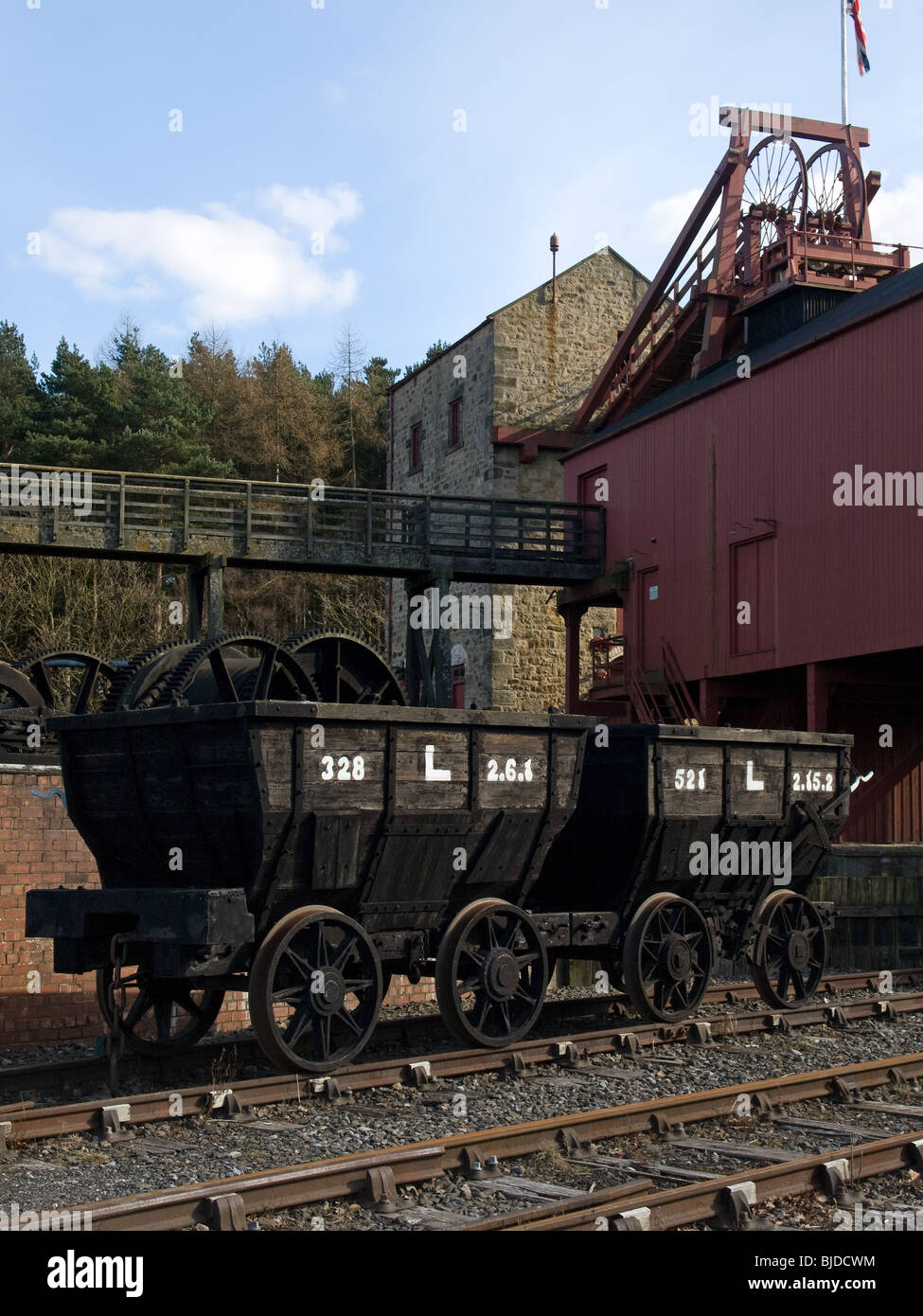 Coal wagons stand along side the reconstructed colliery pit at Beamish ...