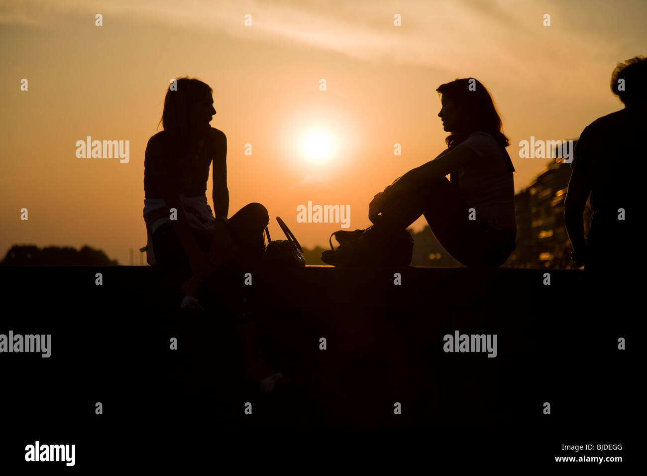 Two people talking at sunset Stock Photo - Alamy