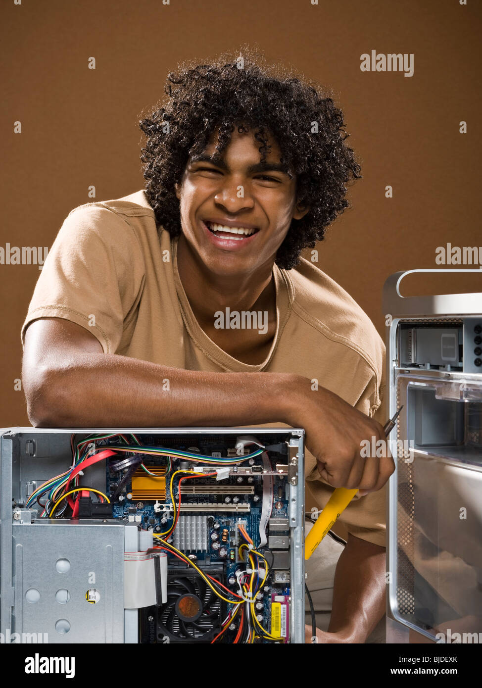 young man in a brown shirt fixing a computer Stock Photo - Alamy