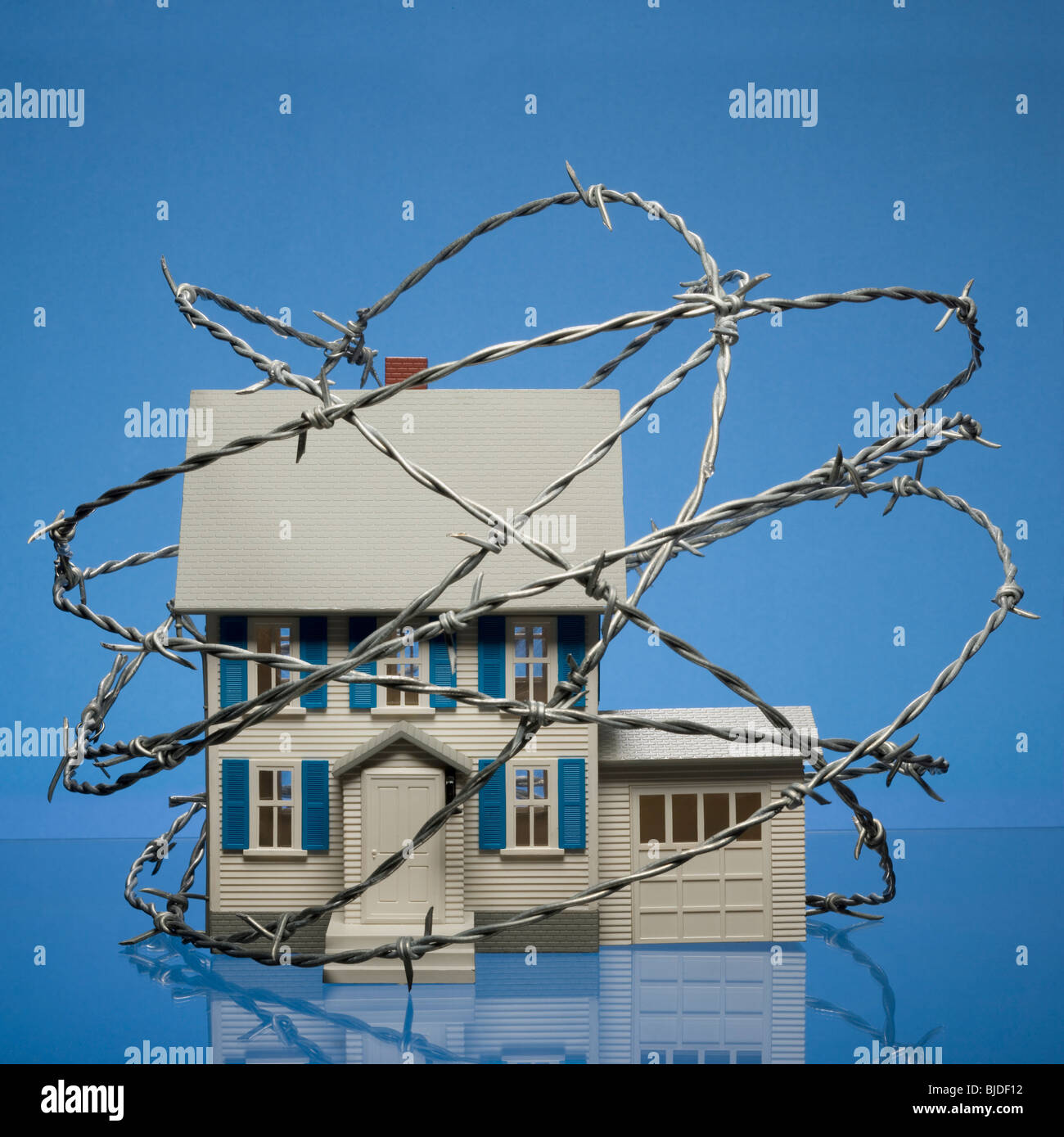 Home surrounded by barbed wire Stock Photo - Alamy