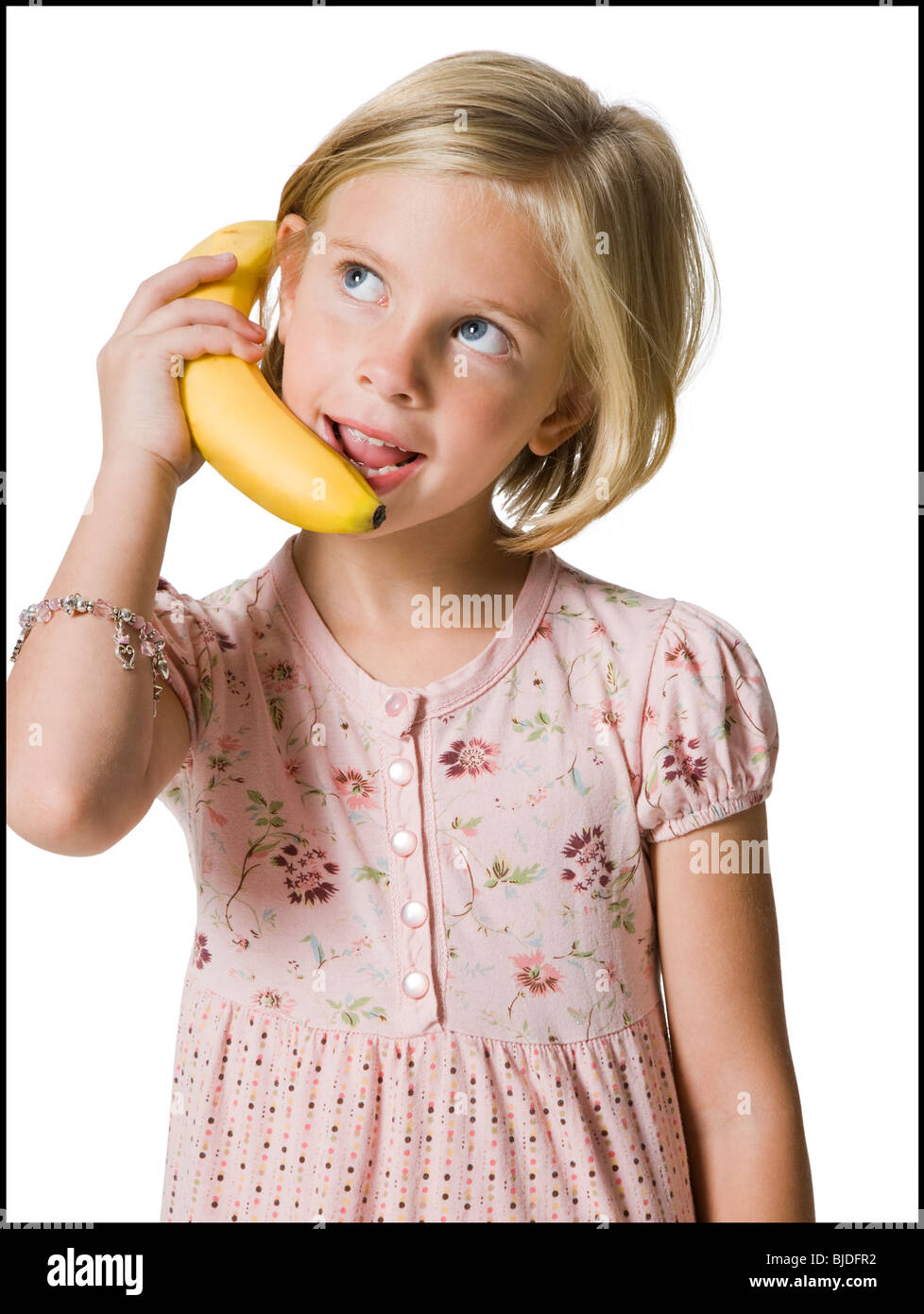 Young girl talking on a banana Stock Photo - Alamy