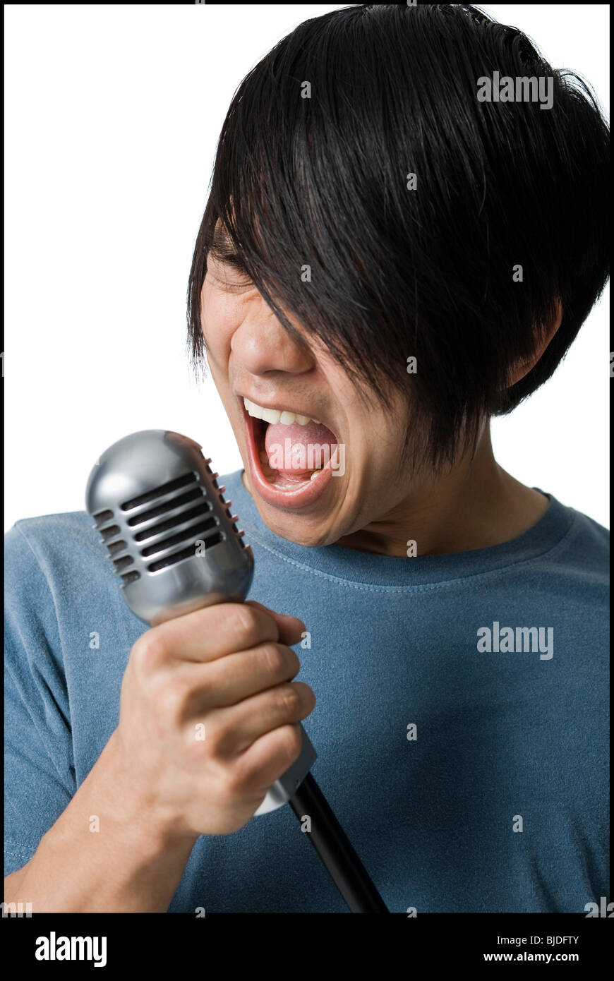 Man rocking out with mic stand Stock Photo - Alamy