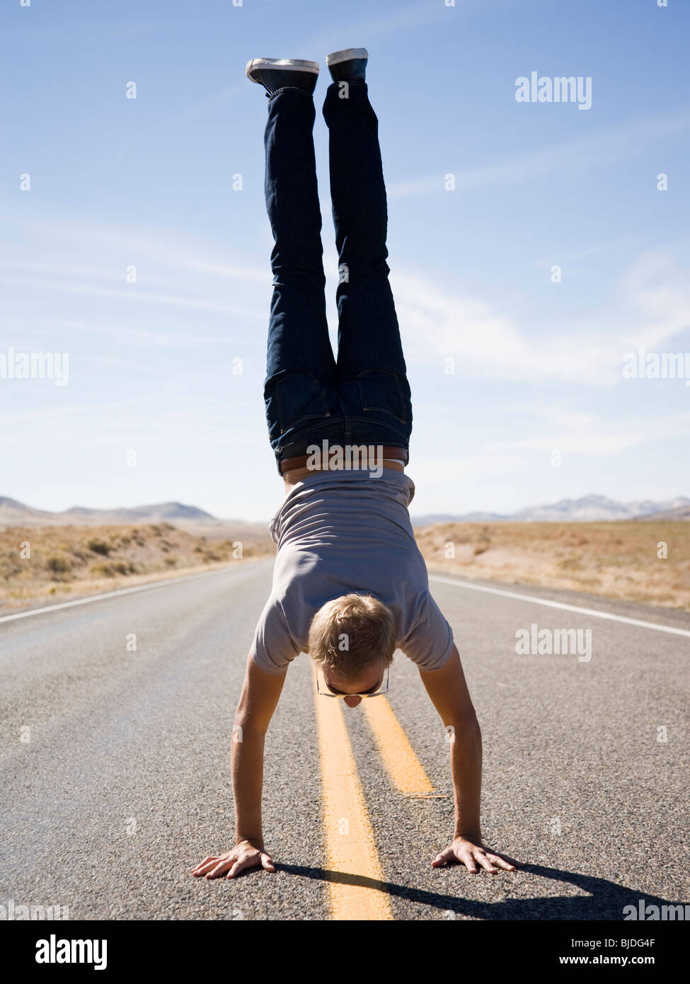man doing a handstand in the middle of the road Stock Photo - Alamy