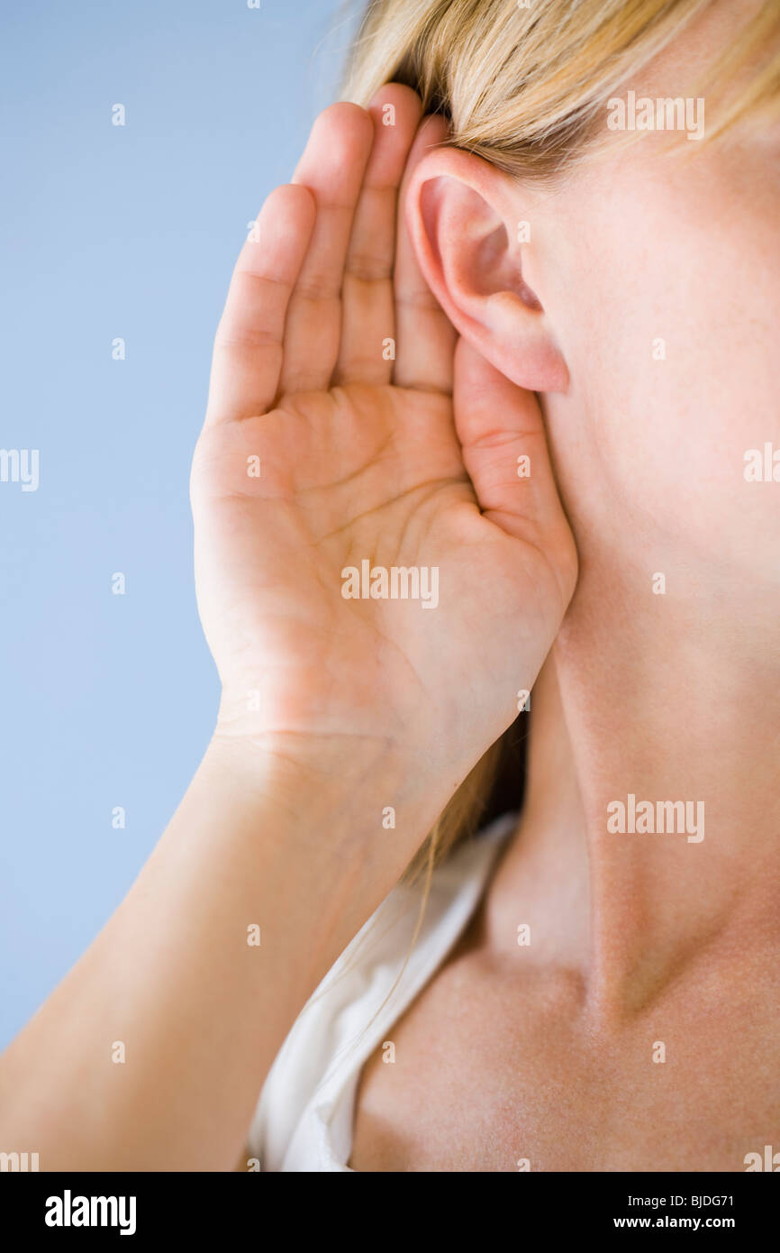 woman holding hand to ear Stock Photo - Alamy