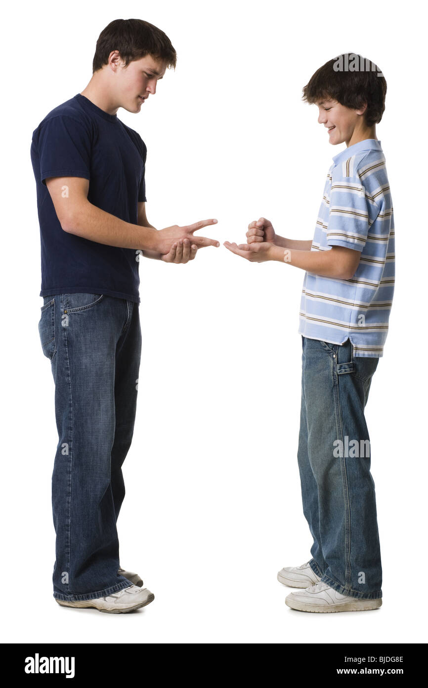 Two young men playing rock, paper, scissors Stock Photo - Alamy