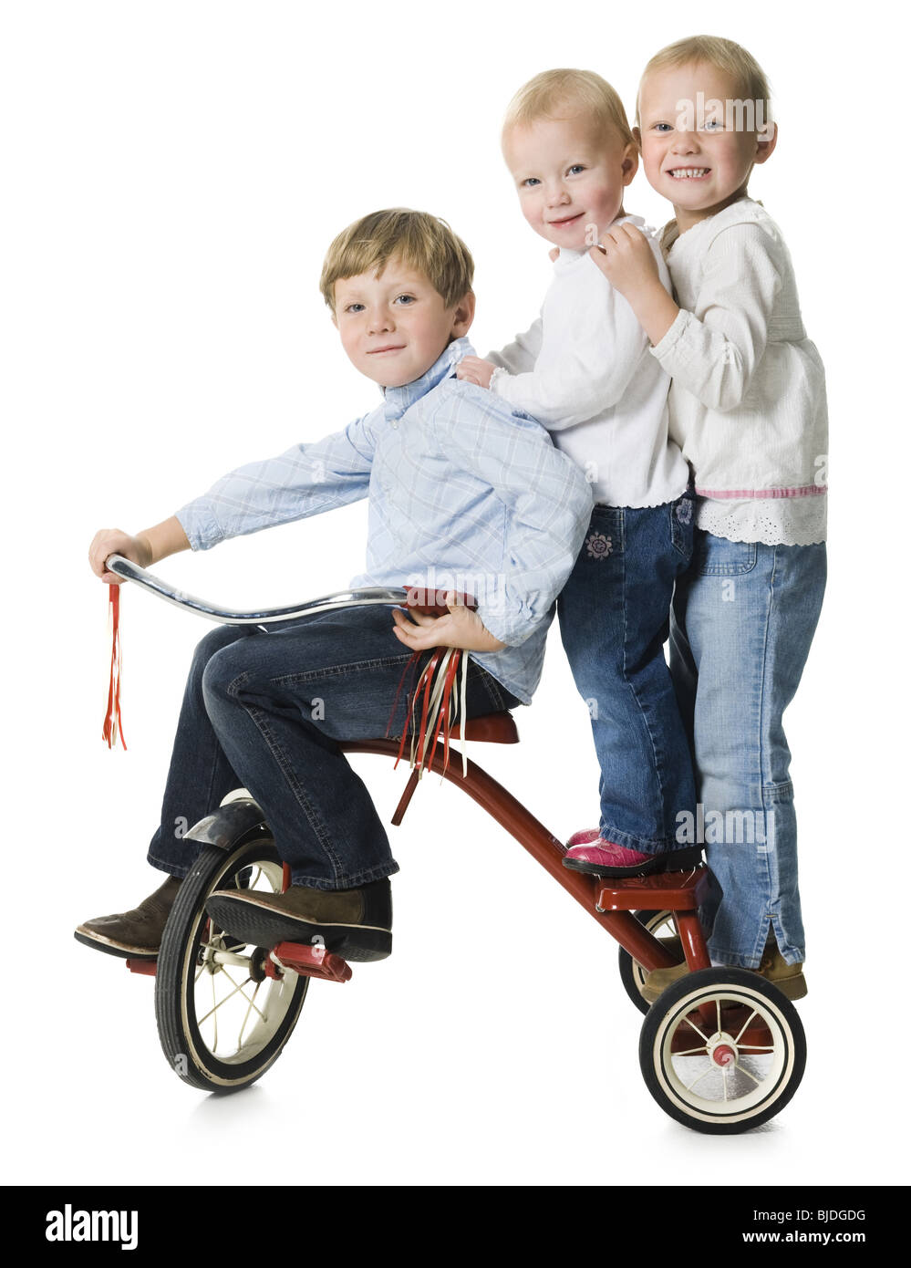 three children on a tricycle Stock Photo - Alamy
