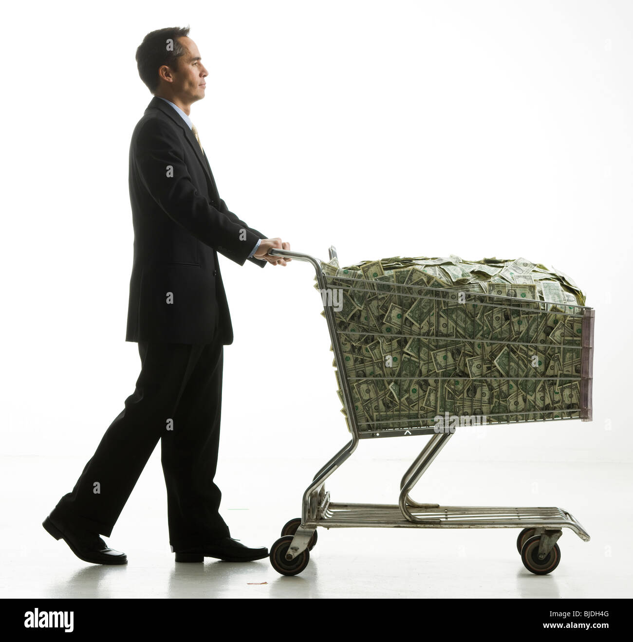 businessperson with a shopping cart full of money Stock Photo - Alamy