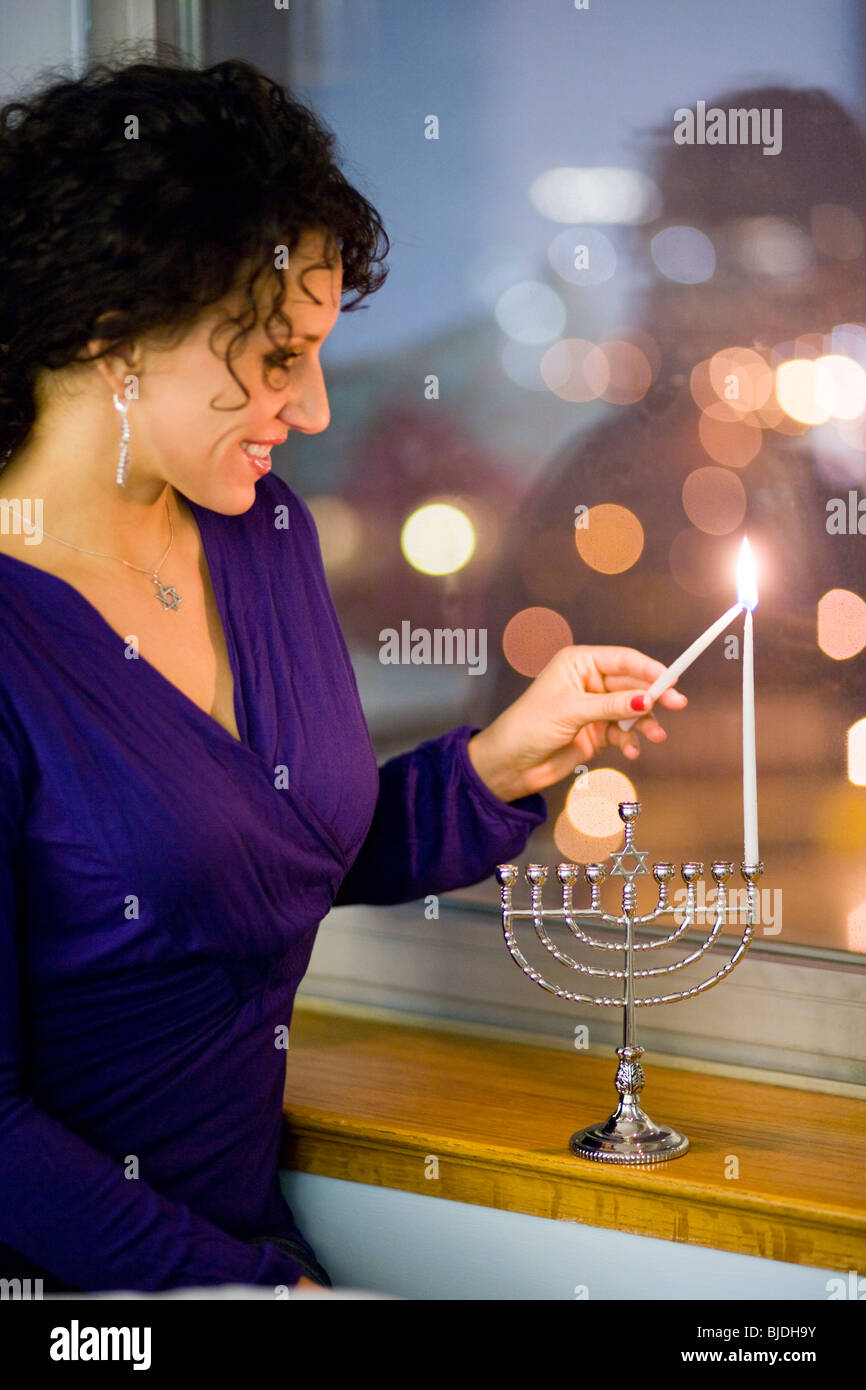 Woman lighting menorah hi-res stock photography and images - Alamy