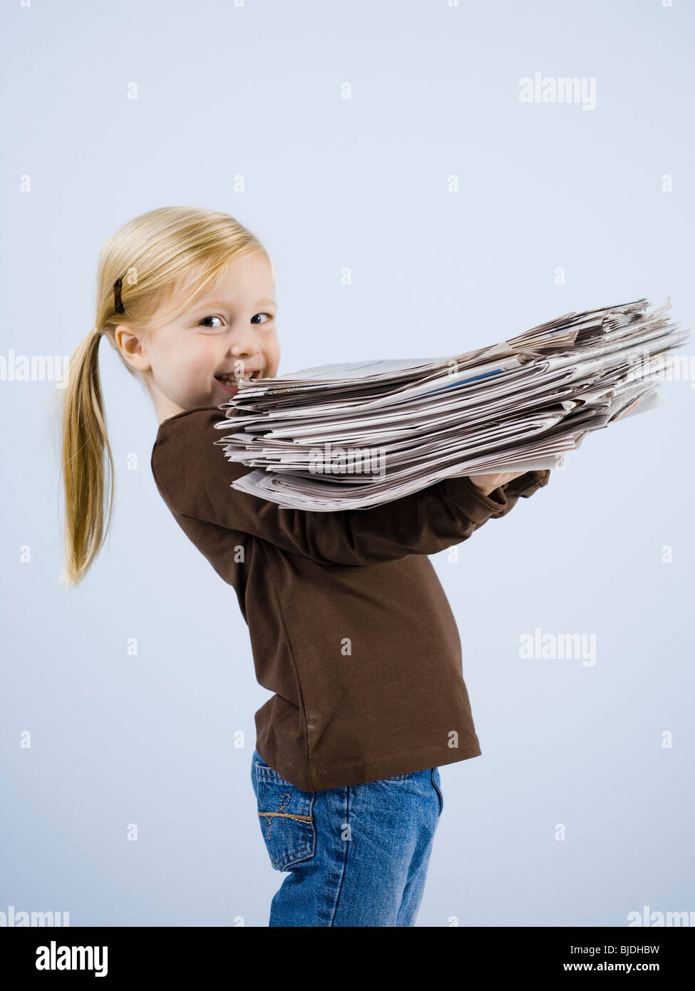 child holding a stack of newspapers Stock Photo - Alamy