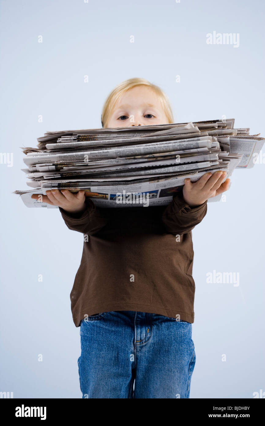 child holding a stack of newspapers Stock Photo - Alamy