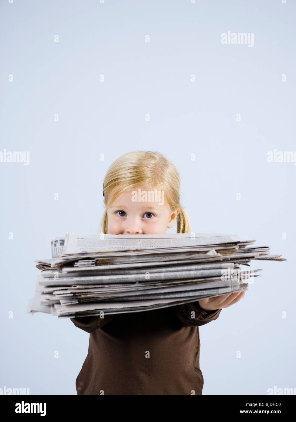 child holding a stack of newspapers Stock Photo - Alamy