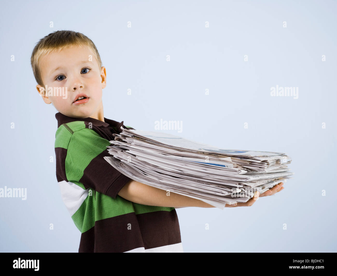 child holding a stack of newspapers Stock Photo - Alamy