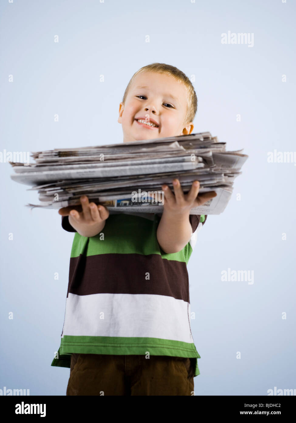 child holding a stack of newspapers Stock Photo - Alamy