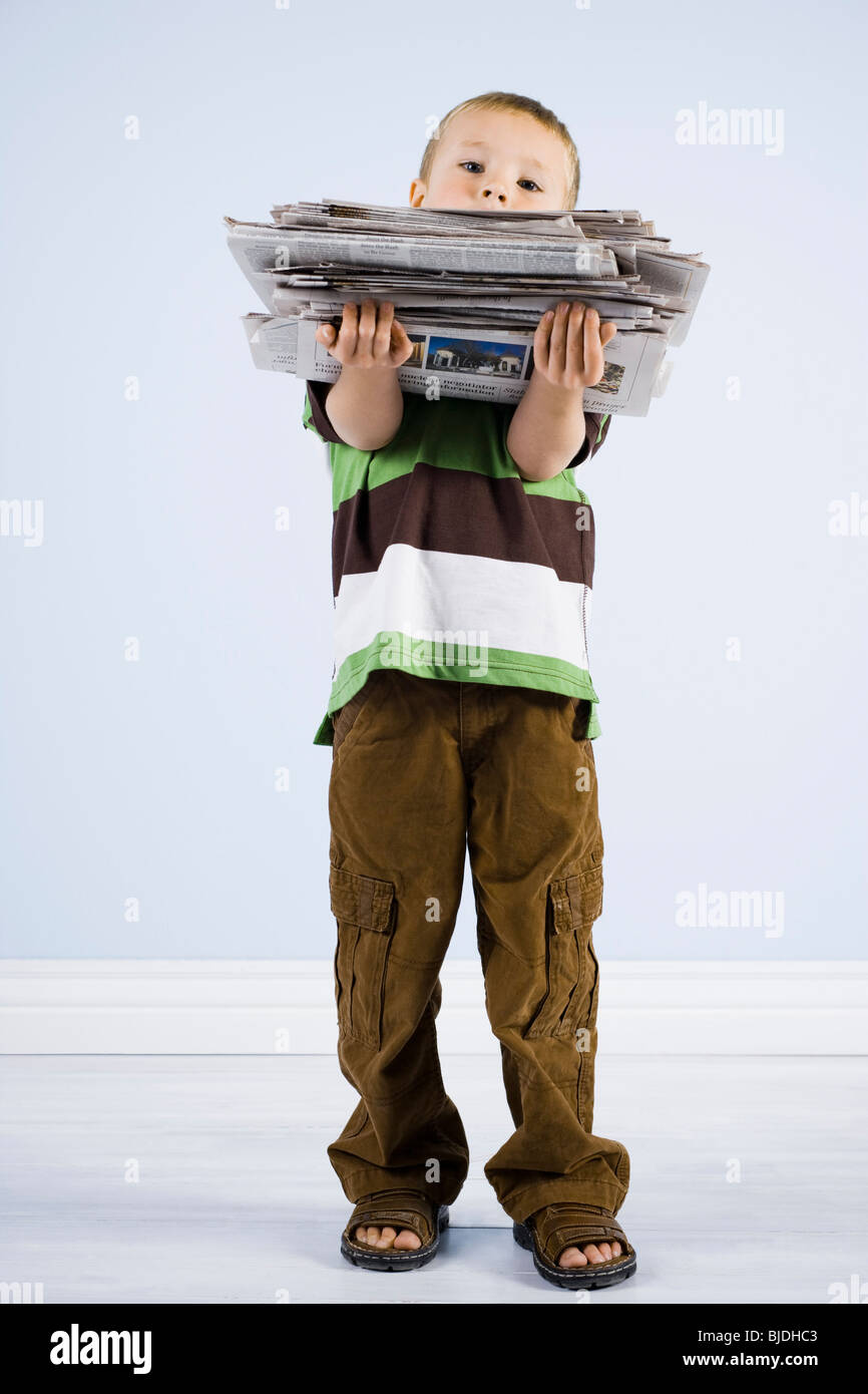child holding a stack of newspapers Stock Photo - Alamy
