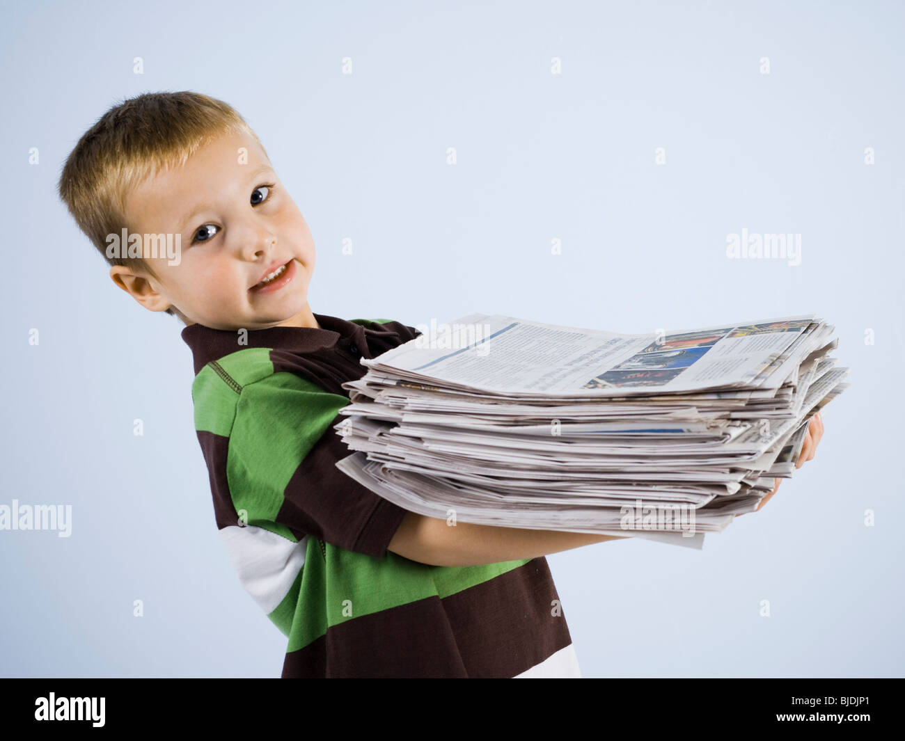child holding a stack of newspapers Stock Photo - Alamy