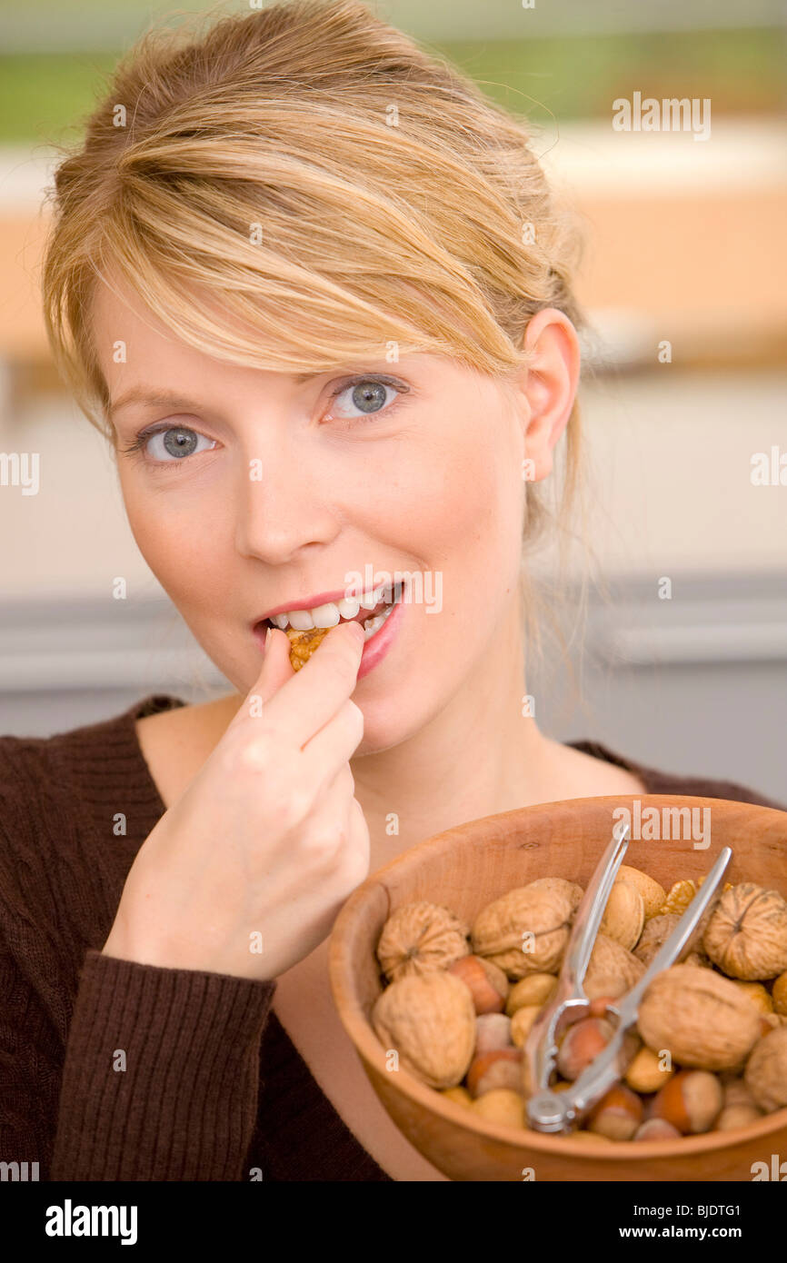 Woman eating nuts Stock Photo - Alamy