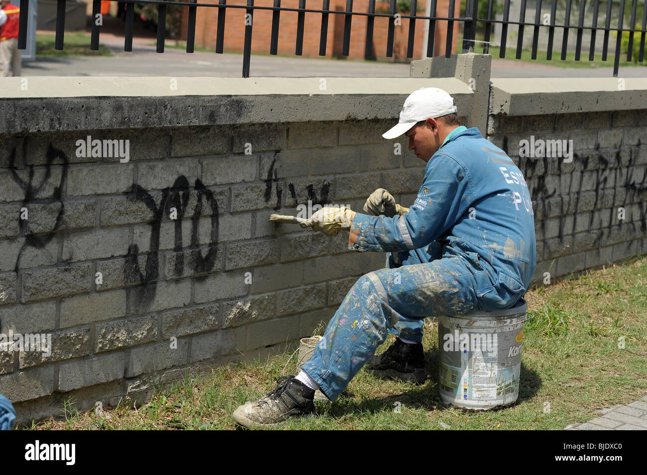 Man painting over graffiti to hide it in preparation for the 2010 South ...